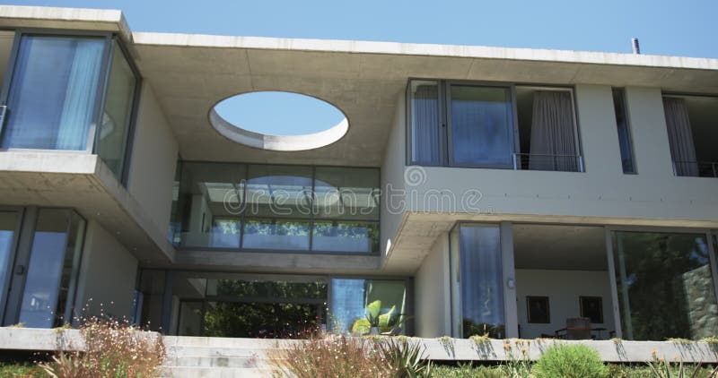 A Modern House Features Large Glass Windows and a Distinctive Circular ...