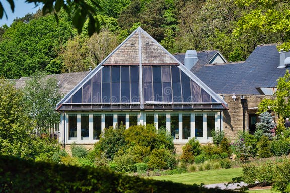 Modern House with Triangular Glass Facade in Lush Greenery Stock Photo ...