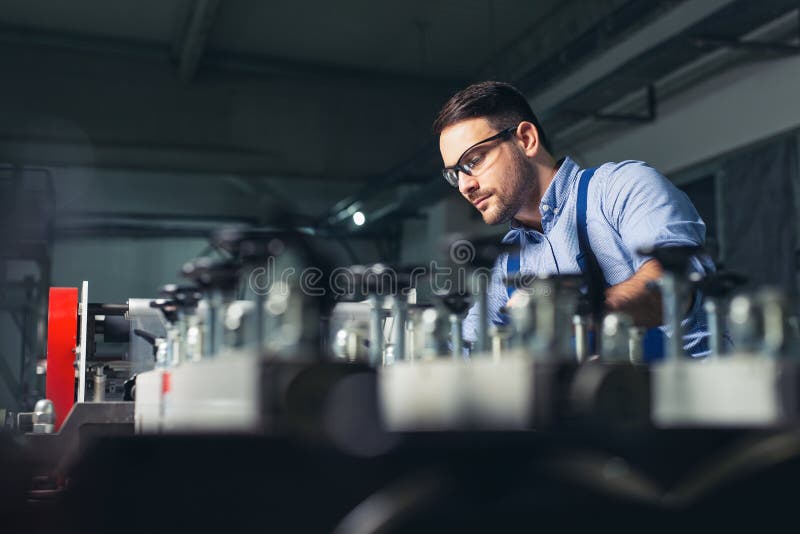Modern Industrial Machine Operator Working in Factory. Worker on the ...