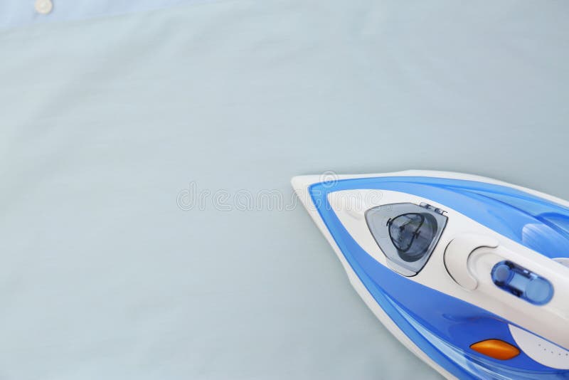 Modern Iron on Light Fabric, Top View. Laundry Day Stock Photo - Image ...
