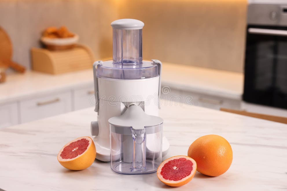 Modern Juicer and Fresh Grapefruits on White Marble Table in Kitchen ...