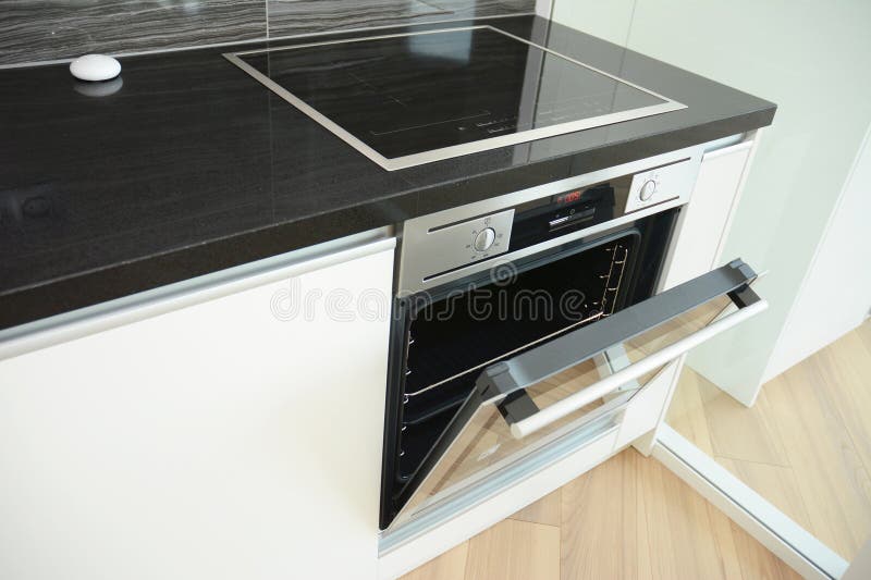 Modern Kitchen with Open Door Electric Oven and Induction Cooktop ...