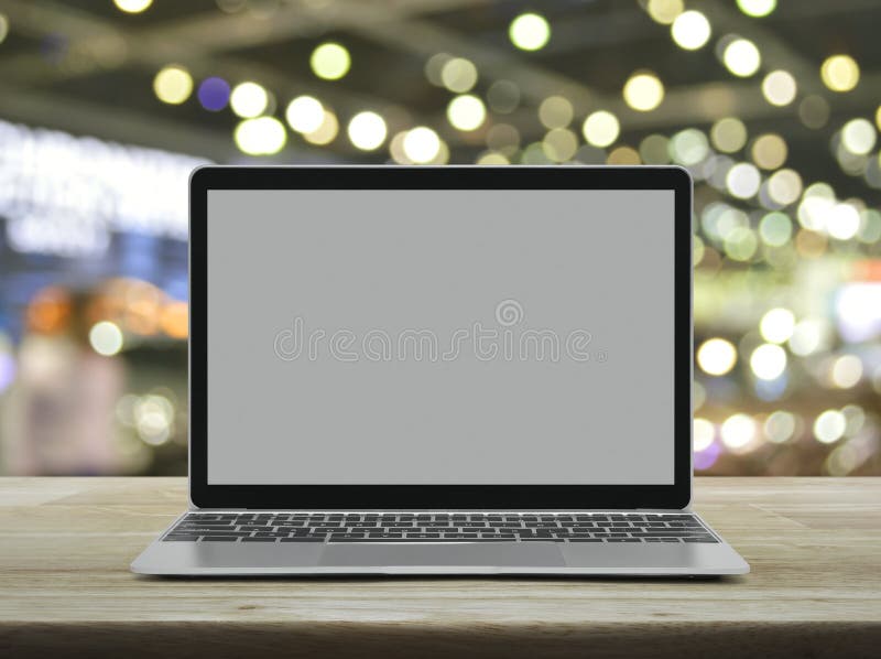 Modern Laptop Computer with Blank Grey Screen on Wooden Table Over Blur ...