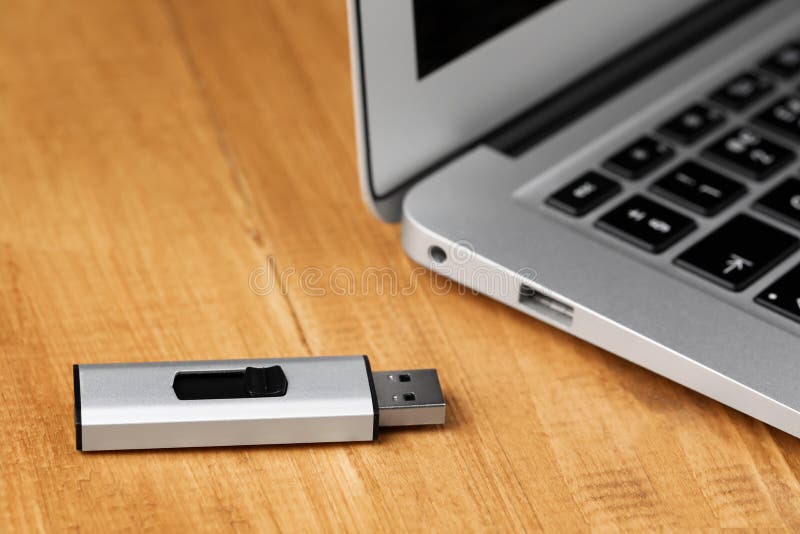 Modern Laptop and Usb Flash Drive on Wooden Table, Closeup Stock Image ...
