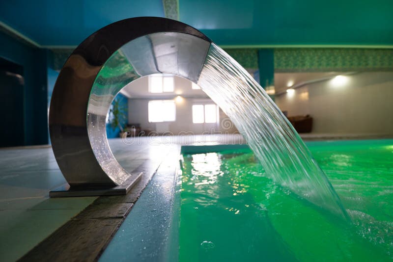 A Modern Large Indoor Pool with Blue Lighting and a Waterfall Stock ...
