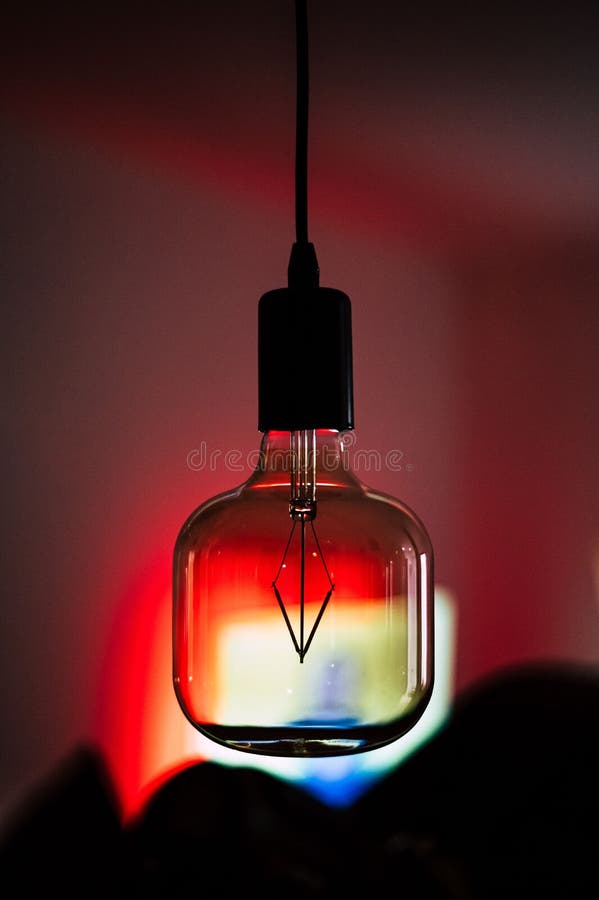 A Modern Light Bulb Turned Off, with a Dimmed Light in the Background ...