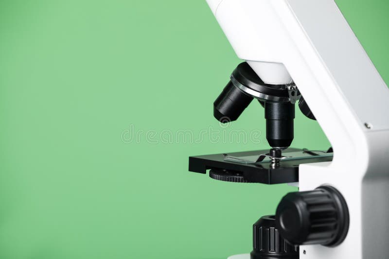 Modern Medical Microscope with Glass Slide on Green Background, Closeup ...