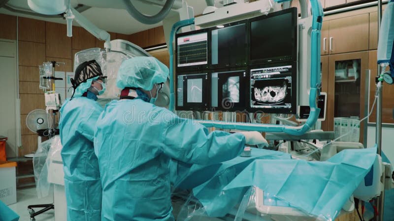 Operating Room in Which Doctors Perform Surgery Looking into Monitors ...