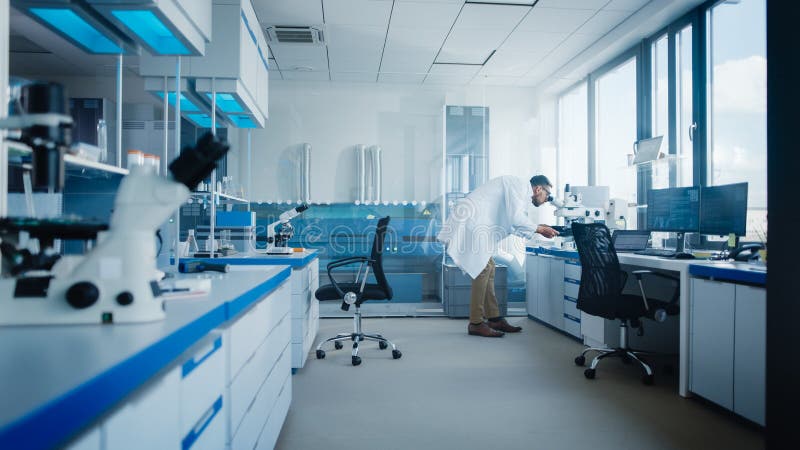 Modern Medical Research Laboratory with Male Scientist Looking Under ...
