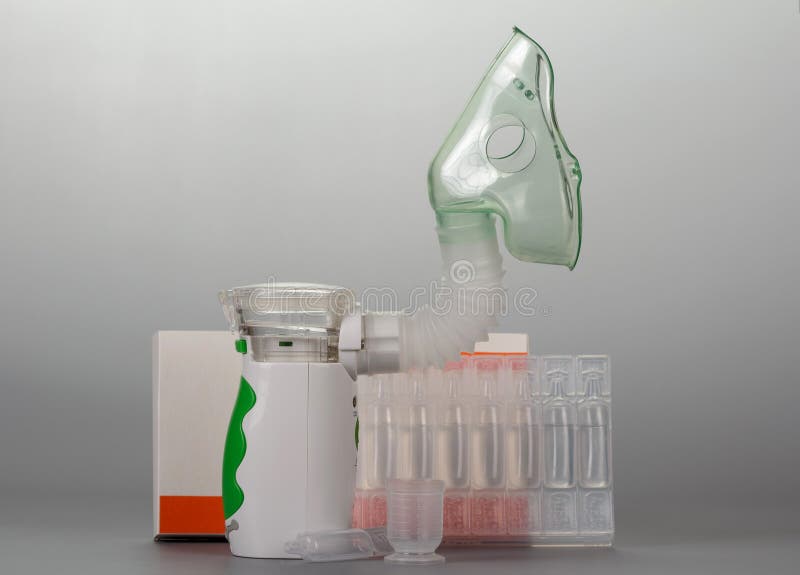 Modern Mesh-nebulizer, Box of Vials and Beaker on Gray Stock Photo ...