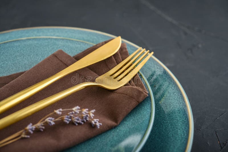 Table Place Setting with Blue Plates and Golden Cutlery on Black ...