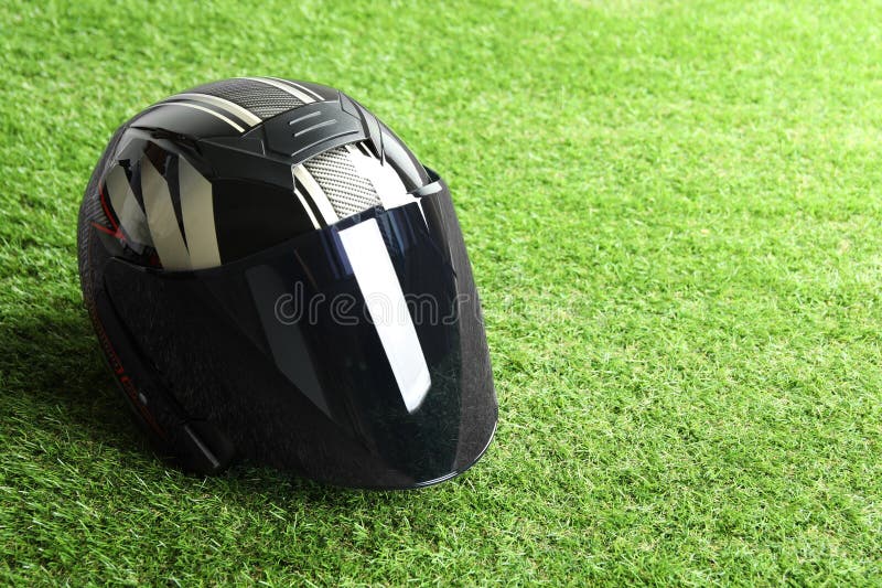 Modern Motorcycle Helmet with Visor on Green Grass Outdoors, Space for ...