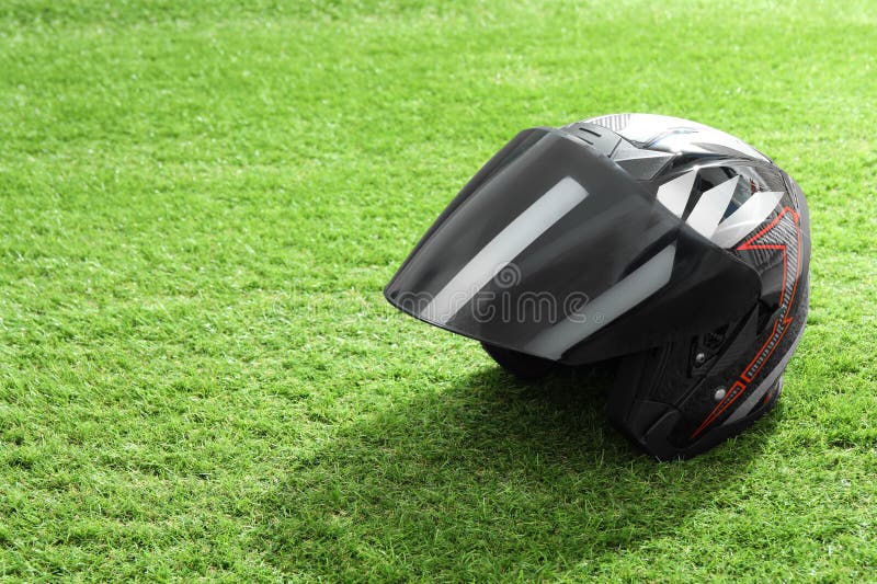 Modern Motorcycle Helmet with Visor on Green Grass Outdoors, Space for ...
