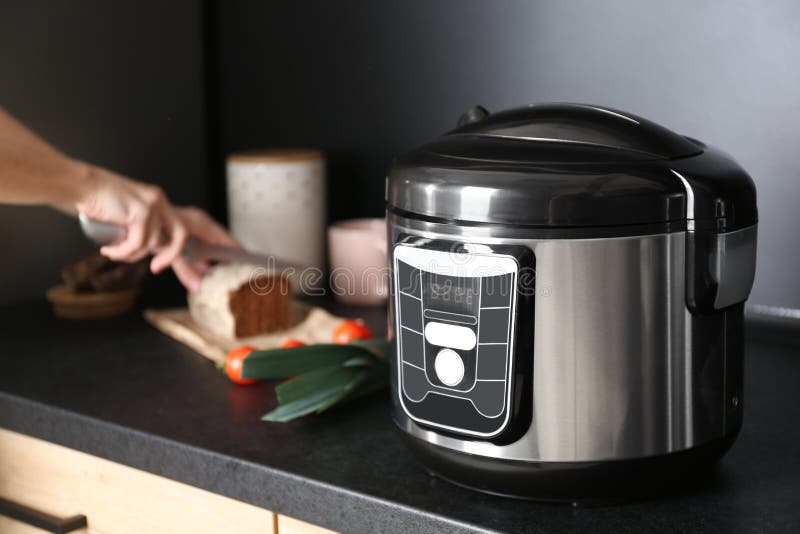 Modern Multi Cooker and Woman Slicing Bread on Table in Kitchen Stock ...