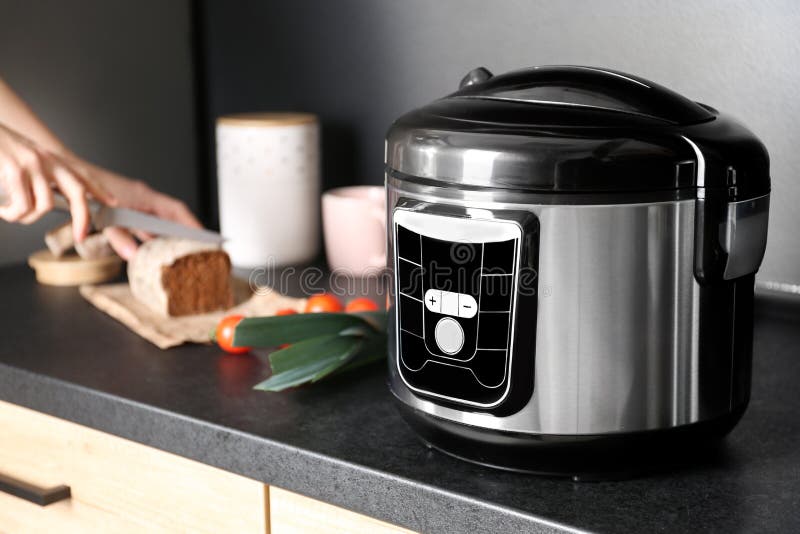 Modern Multi Cooker and Woman Slicing Bread on Table in Kitchen Stock ...