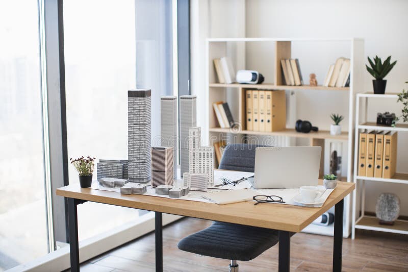 Modern Office Desk with Architectural Model and Laptop Setup Stock ...
