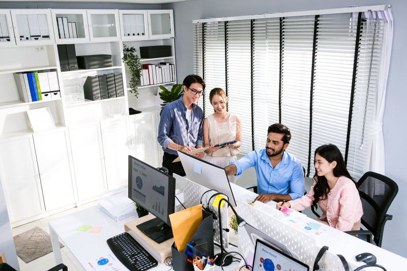 A Modern Office Setting with a Diverse Team Collaborating Over a ...