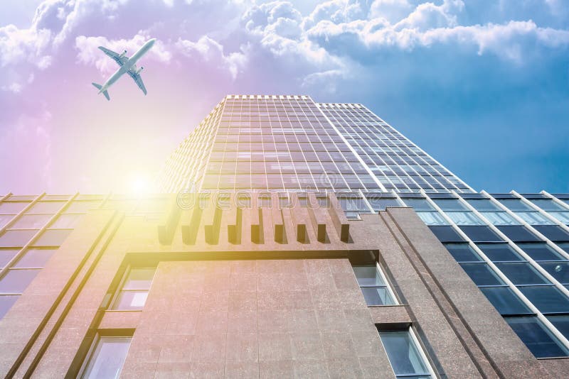 A Modern Office Skyscraper and a White Passenger Airliner Flying Over ...