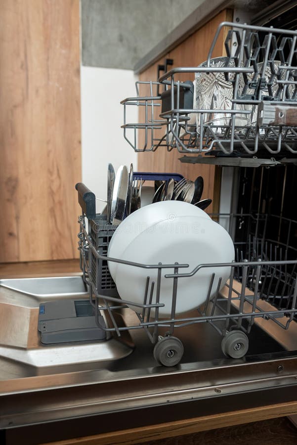 Modern Open Dishwasher with Clean Dishes after Washing Cycle at Kitchen ...