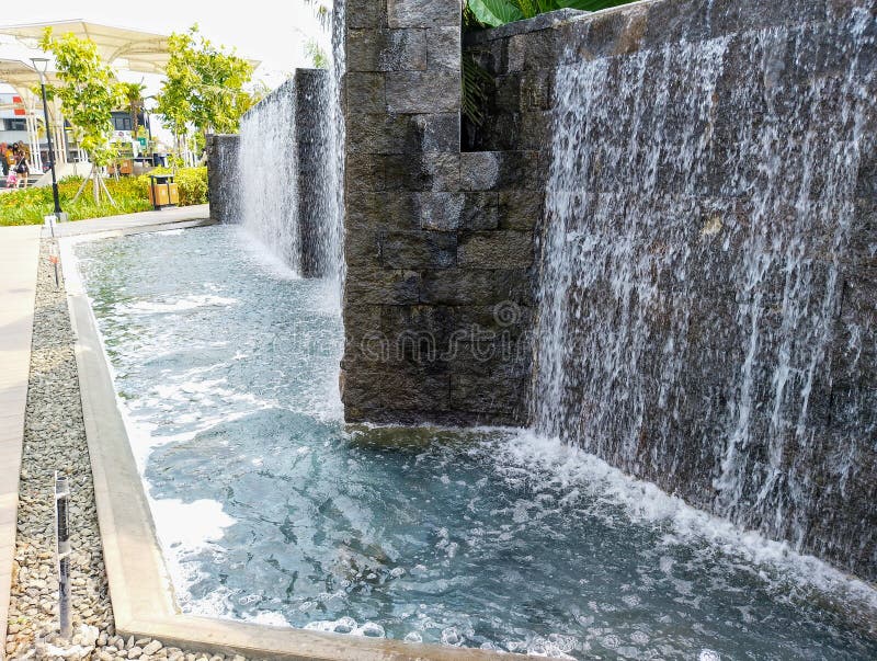 Modern Cascading Water Feature with Stone Wall and Pool Stock Image ...