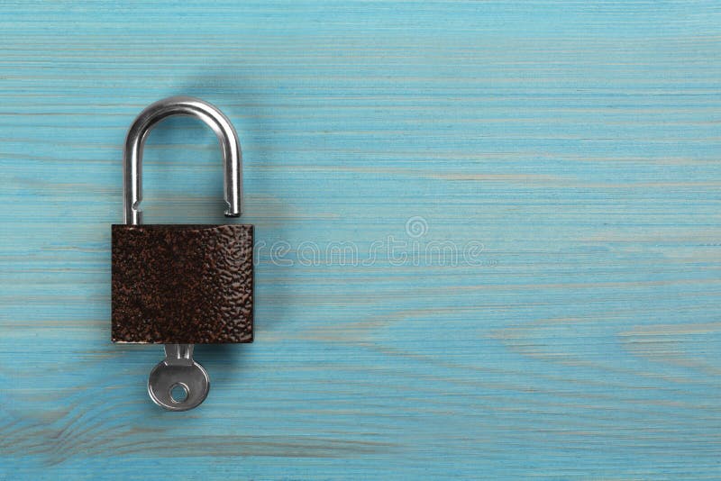 Modern Padlock with Key on Light Blue Wooden Table, Top View. Space for ...