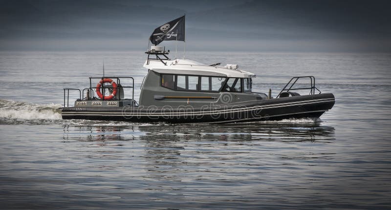 Modern Pirates on a Motor Boat in a Bay Under a Pirate Flag Stock Image ...