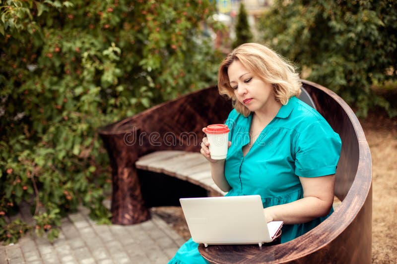 Modern Plus Size Woman Working on Laptop in Park, Drinking Coffee from ...