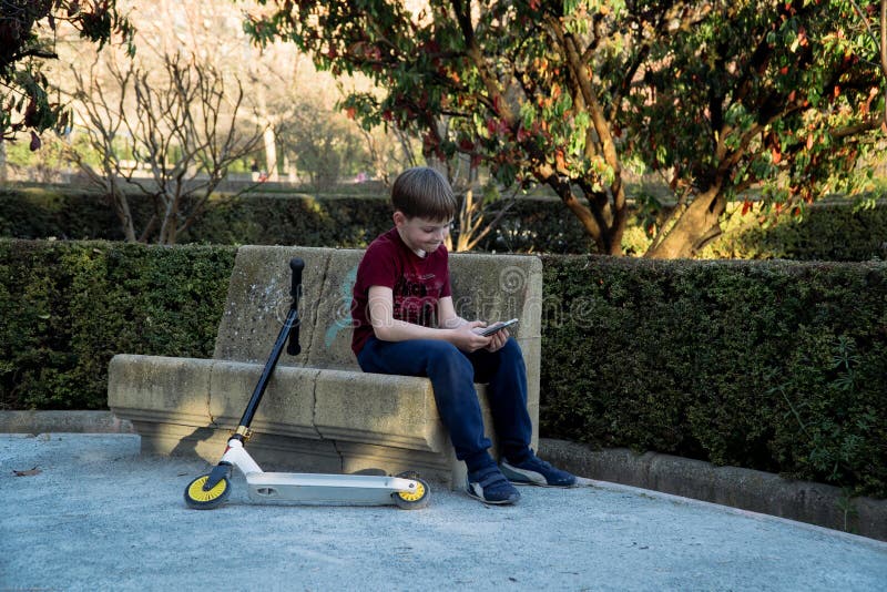 Modern Problems of Children. the Child Plays with the Phone in the Park ...
