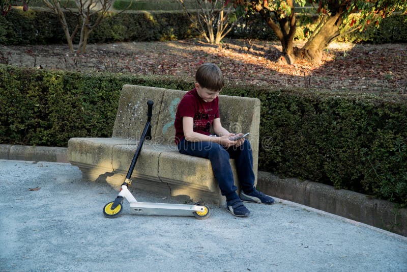 Modern Problems of Children. the Child Plays with the Phone in the Park ...