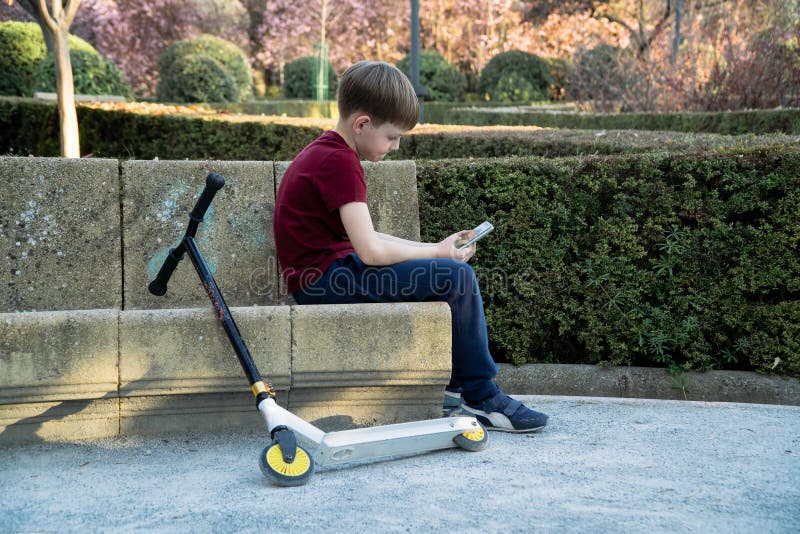 Modern Problems of Children. the Child Plays with the Phone in the Park ...