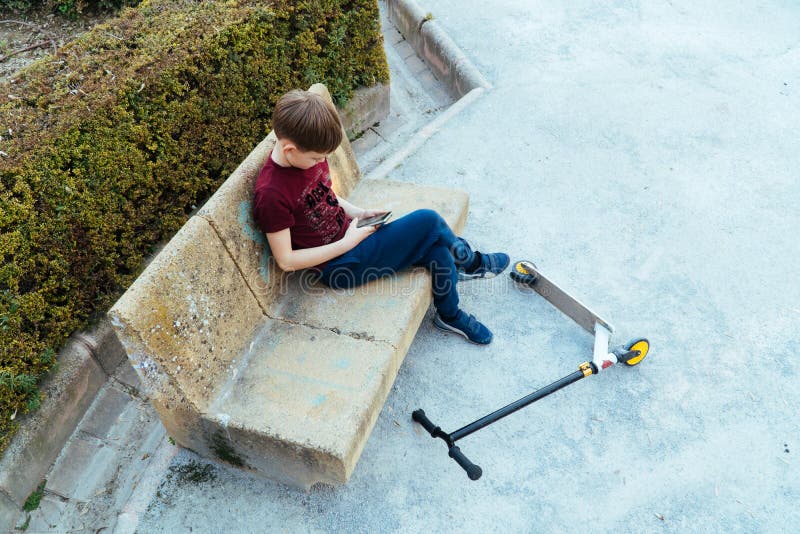 Modern Problems of Children. the Child Plays with the Phone in the Park ...