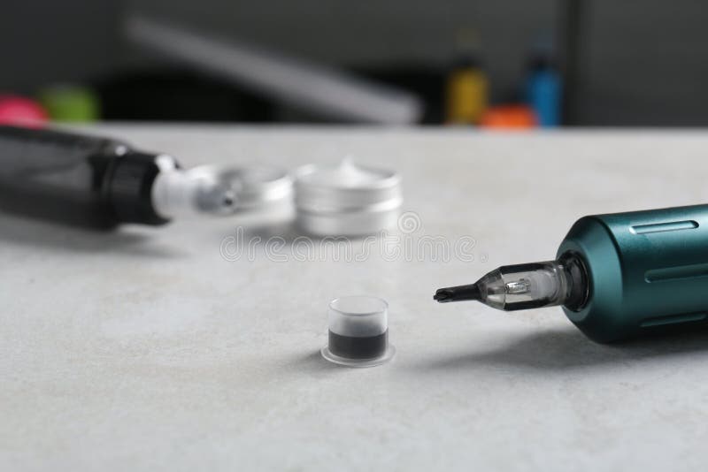 Modern Professional Tattoo Machine and Cap with Ink on White Table in ...