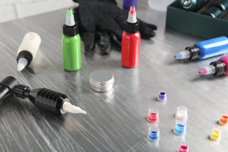 Modern Professional Tattoo Machine, Colorful Inks and Ointment on Table ...