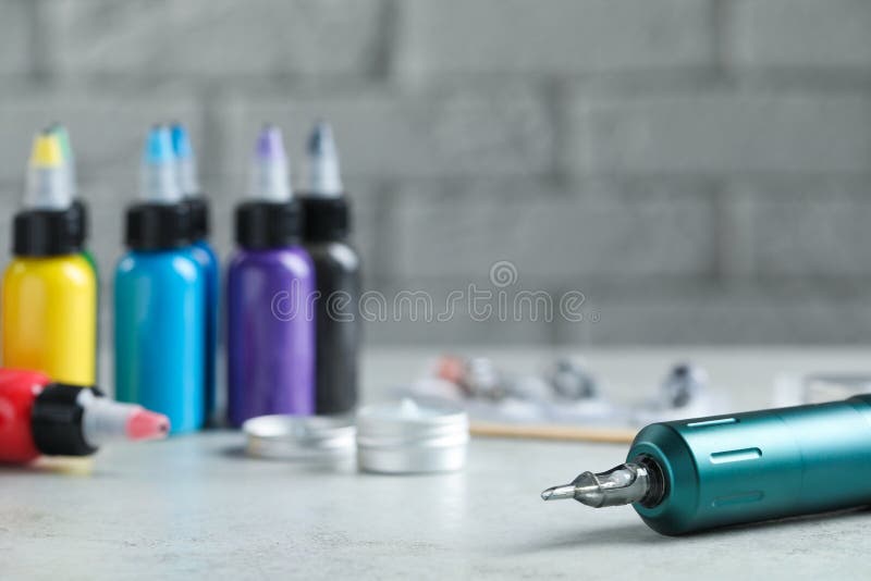 Modern Professional Tattoo Machine and Colorful Inks on White Table ...