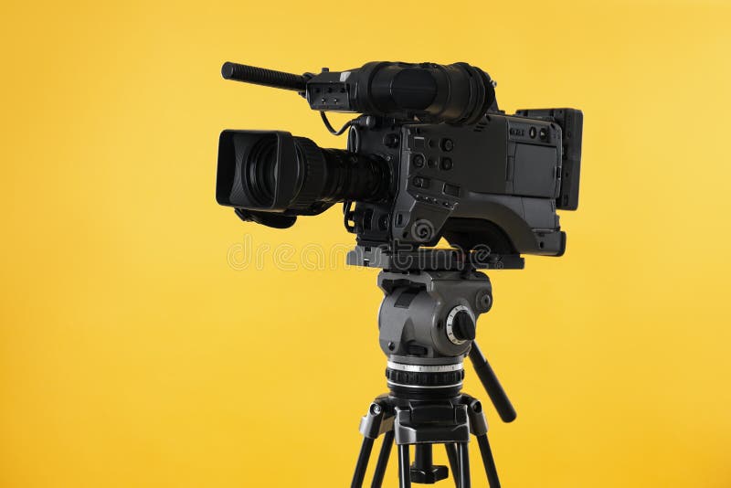 Modern Professional Video Camera on Yellow Background Stock Image ...