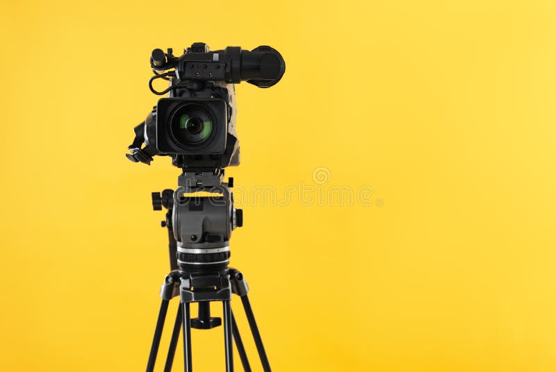 Modern Professional Video Camera on Yellow. Space for Text Stock Photo ...