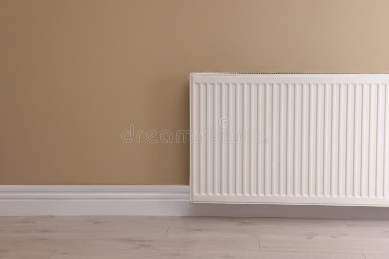 Modern Radiator on Beige Wall, Space for Text. Central Heating System ...