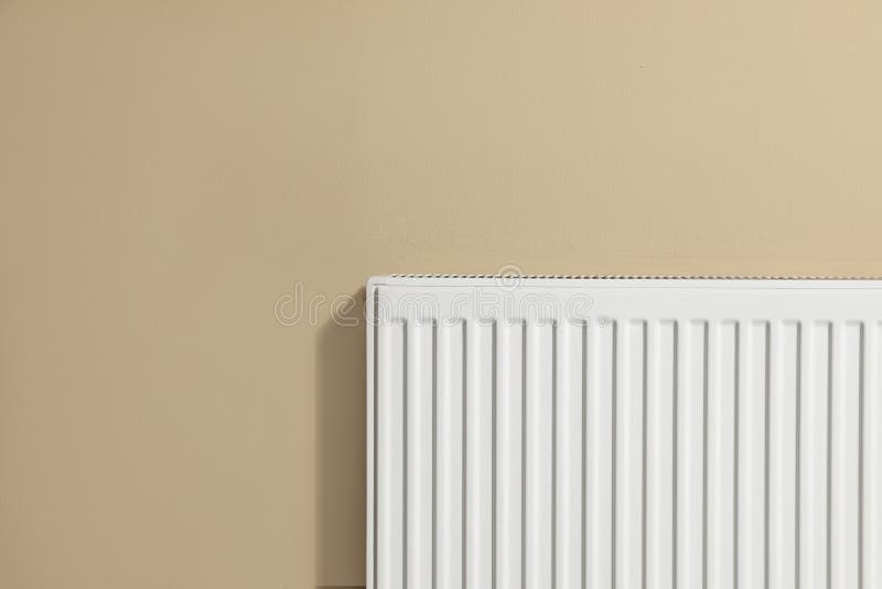 Modern Radiator on Beige Wall, Space for Text. Central Heating System ...
