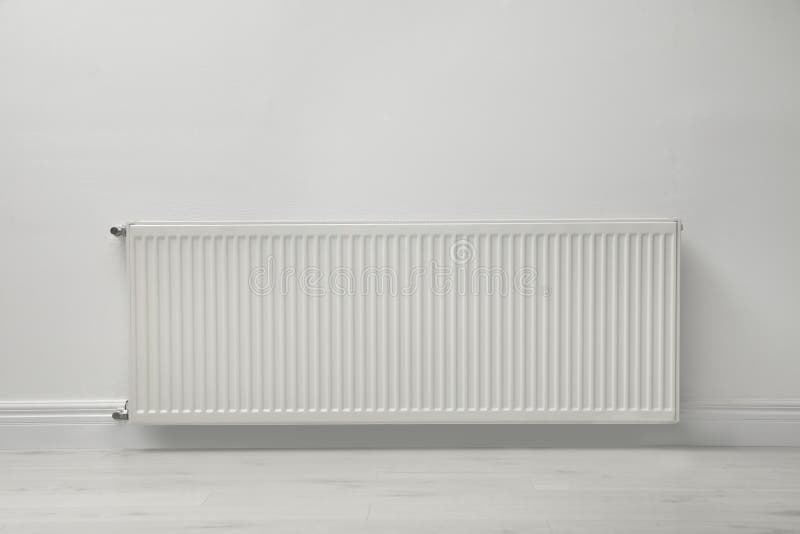 Modern Radiator on White Wall Indoors. Central Heating System Stock ...