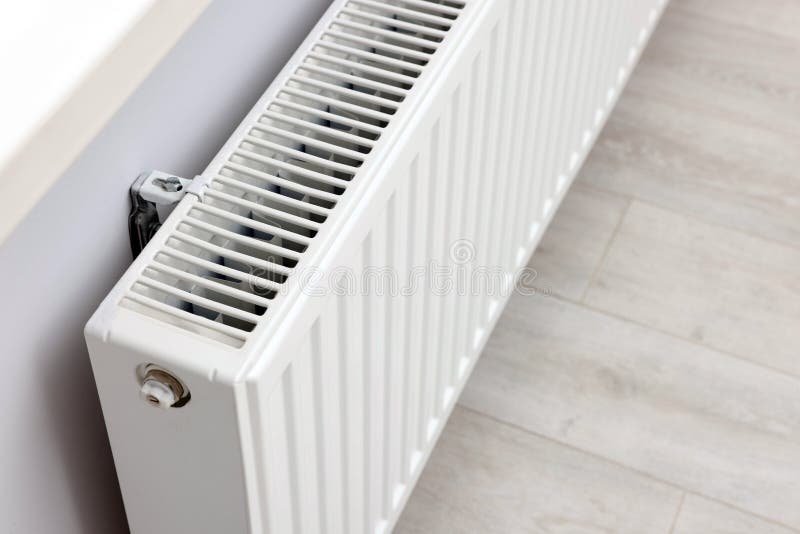 Modern Radiator on White Wall in Room, Closeup. Central Heating System ...