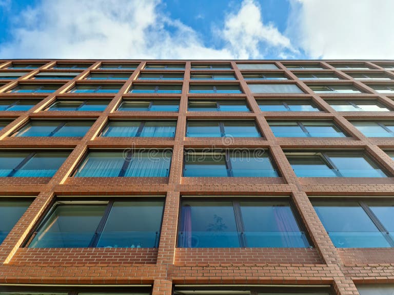 Modern Red Brick Building Facade with Repeating Windows Reaching for ...