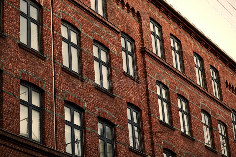 Modern Red Stone Building with Large Black Windows Under a Grey Sky ...
