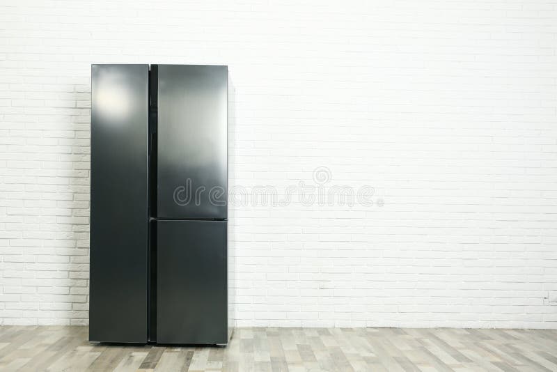 Modern Refrigerator Near White Brick Wall Stock Image - Image of ...