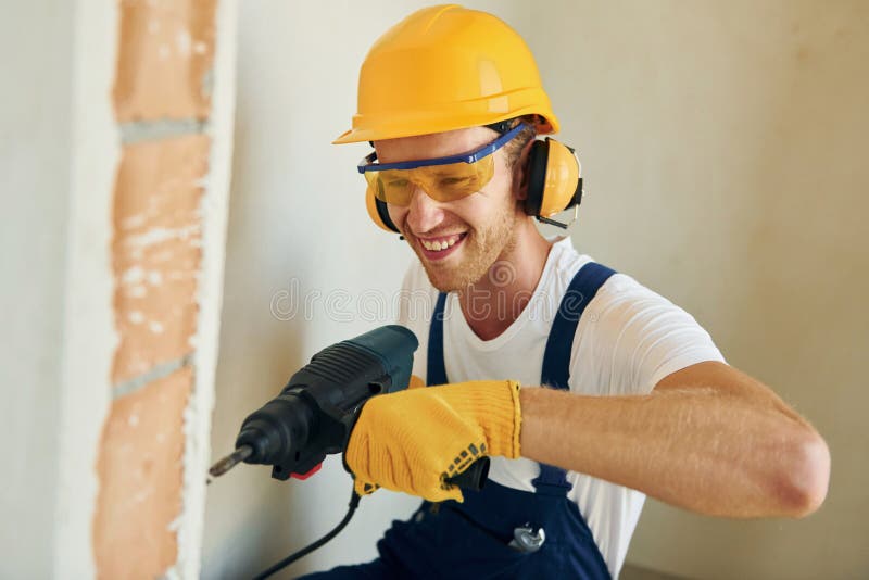 Modern Repair. Young Man Working in Uniform at Construction at Daytime ...