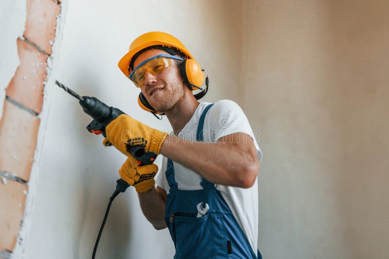 Modern Repair. Young Man Working in Uniform at Construction at Daytime ...