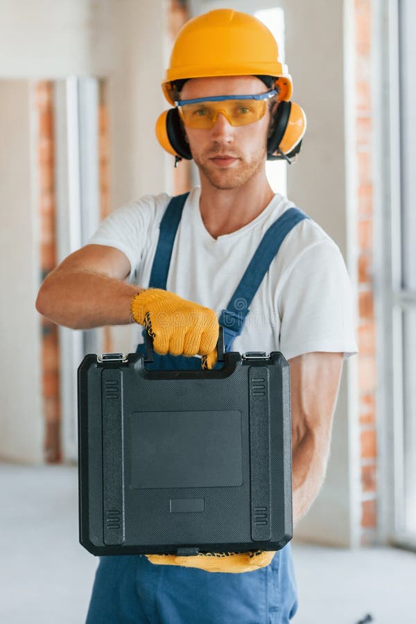 Modern Repair. Young Man Working in Uniform at Construction at Daytime ...