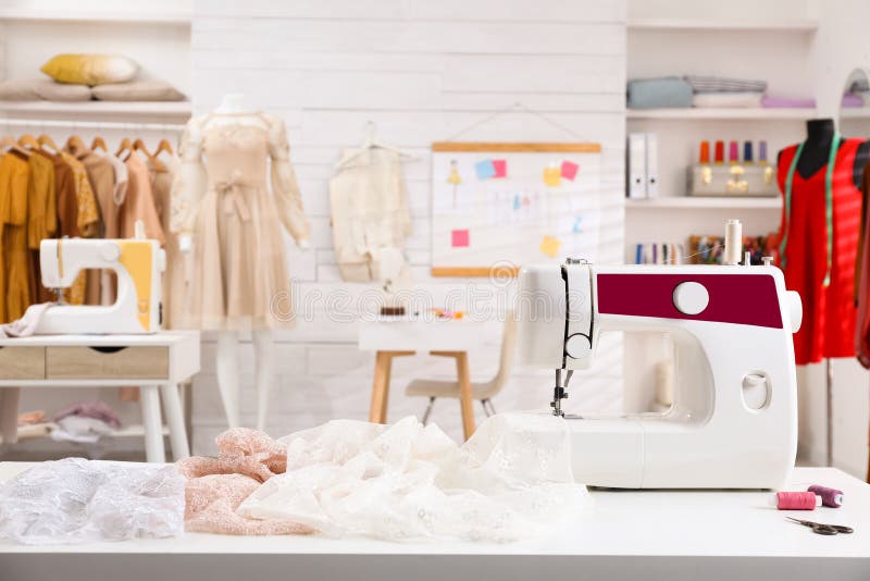 Modern Sewing Machine with Fabric on Table in Dressmaking Workshop ...