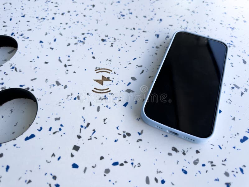 Modern Smartphone Placed on Wireless Charging Symbol on Speckled Table ...