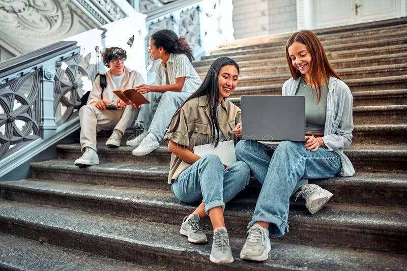 Modern Students Sit on the Stairs and Discuss Their Studies. Stock ...
