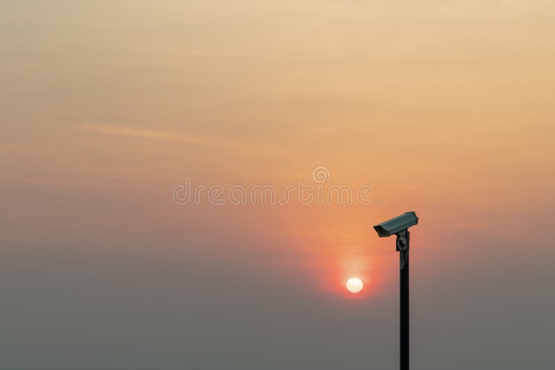 Modern Surveillance Camera in the Foreground the Orange Sun Shing ...
